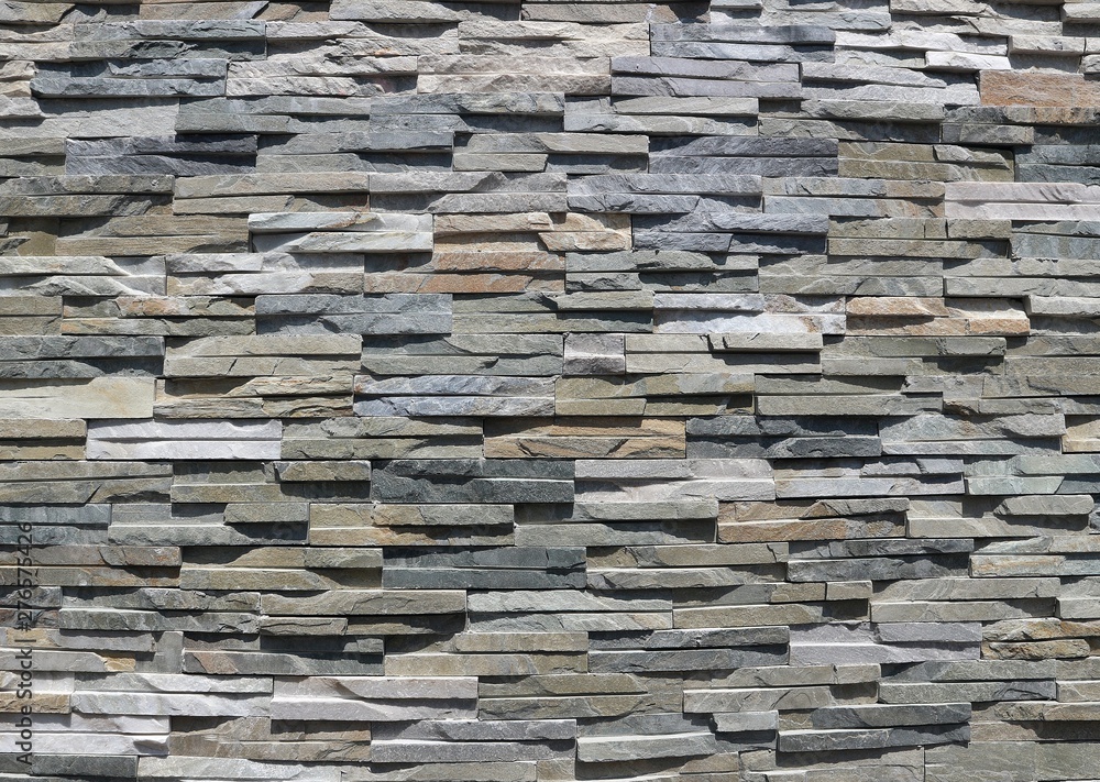 Stone wall cladding made of uneven natural rock strips of different ...