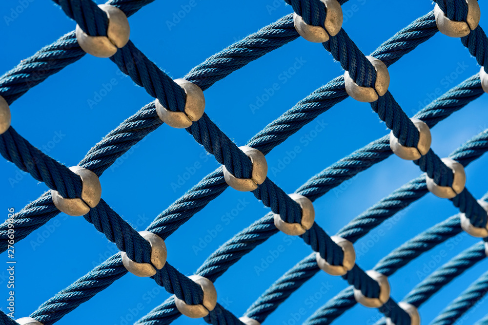 Bright blue rope mesh against a bright blue sky close-up. Background ...