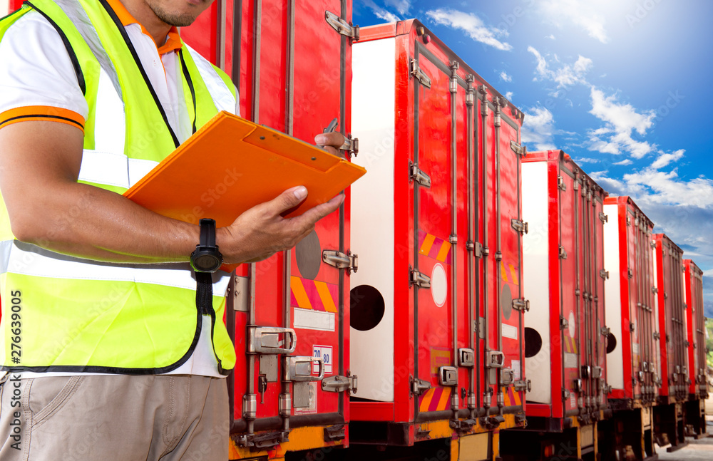 Worker Holds a Clipboard Controlling the Loading of Cargo into Shipping ...