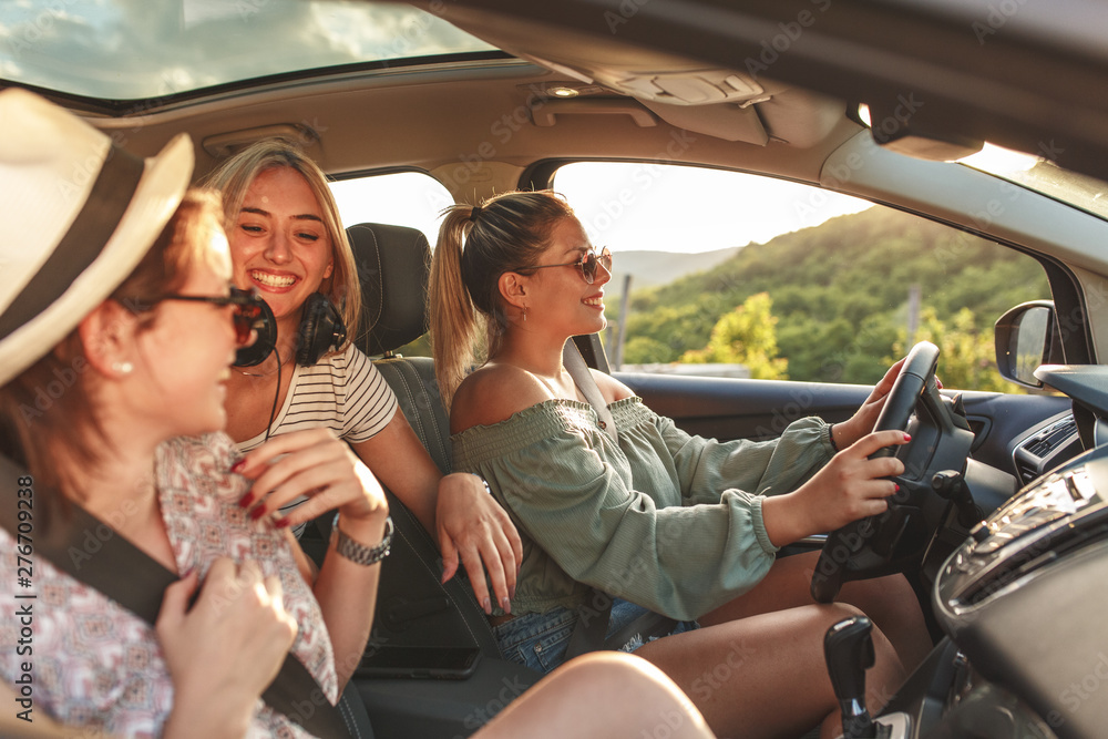 Three best female friends travel together. They drive a car and making ...