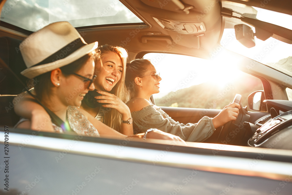 Three best female friends travel together. They drive a car and having ...