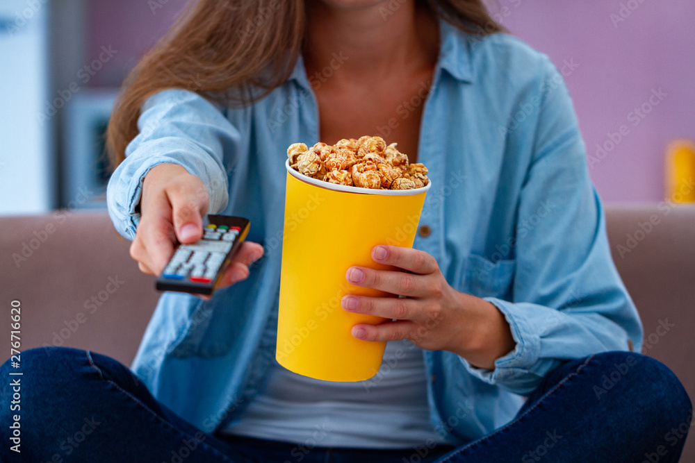 Woman resting and eating crispy caramel popcorn for snack during ...
