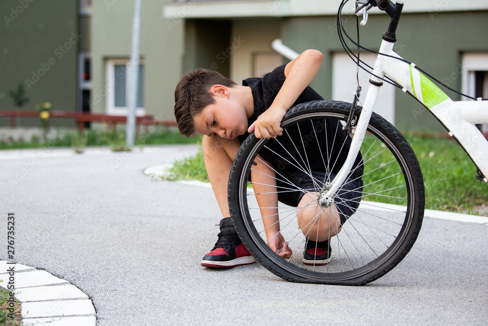 Sad boy looking at his flat bike tire, kid staring at the bicycle with ...