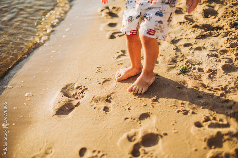 Legs of children stand on the beach. Baby feet in the sand. Summer ...