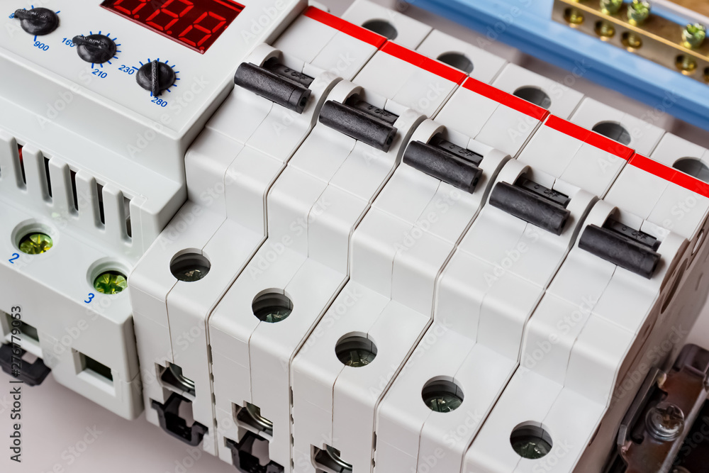 Automatic circuit breakers and voltage limiter on DIN rail in white ...