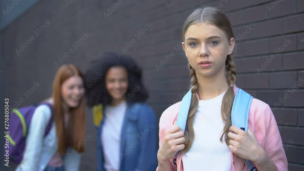Confused bullying victim looking camera, female students laughing ...