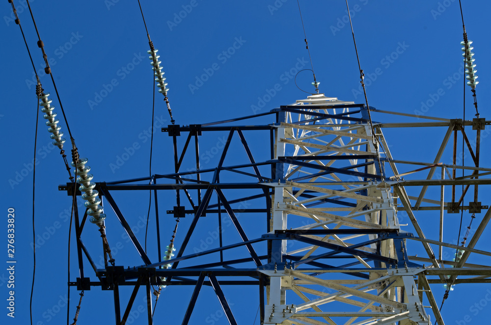 A white metal frame structure tapering upwards is a power transmission ...