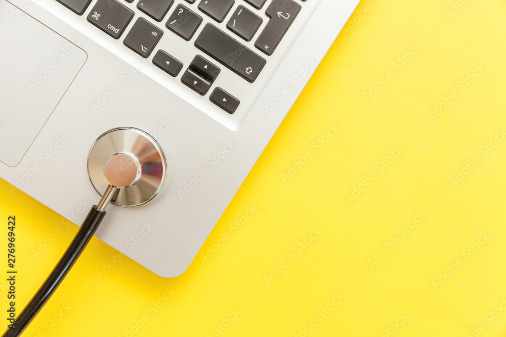 Stethoscope keyboard laptop computer isolated on yellow background ...