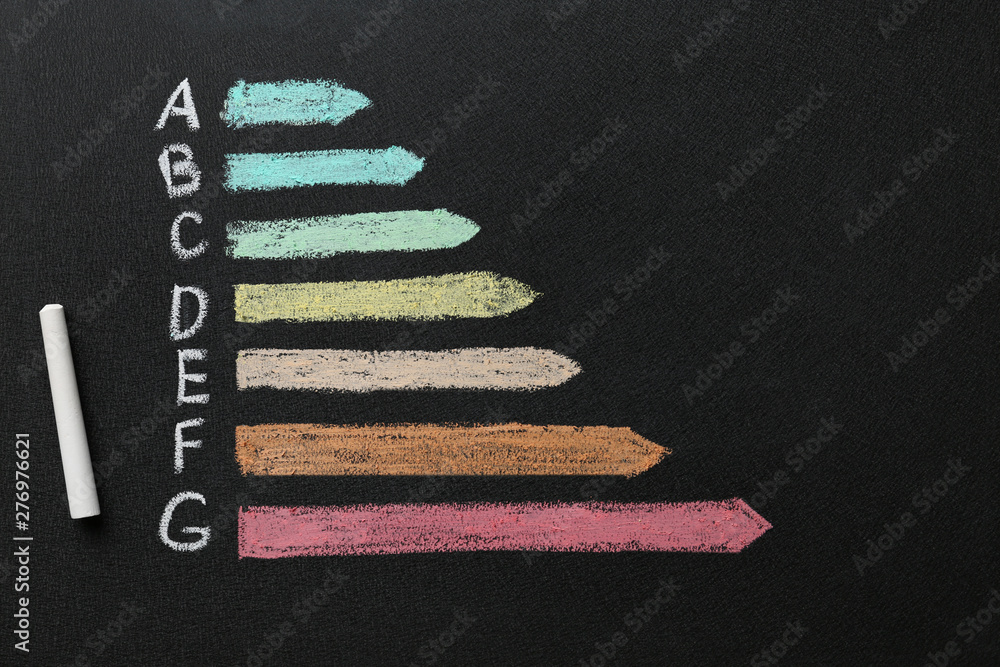 Energy efficiency rating chart and chalk on black background, top view ...
