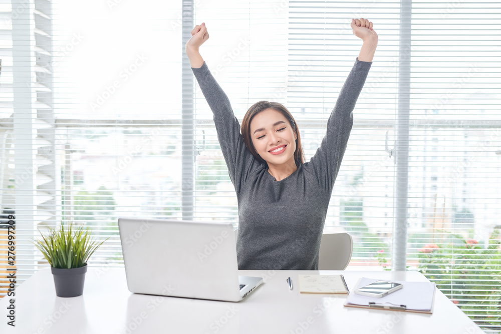 Satisfied woman relaxing with hands behind her head. Happy smiling ...