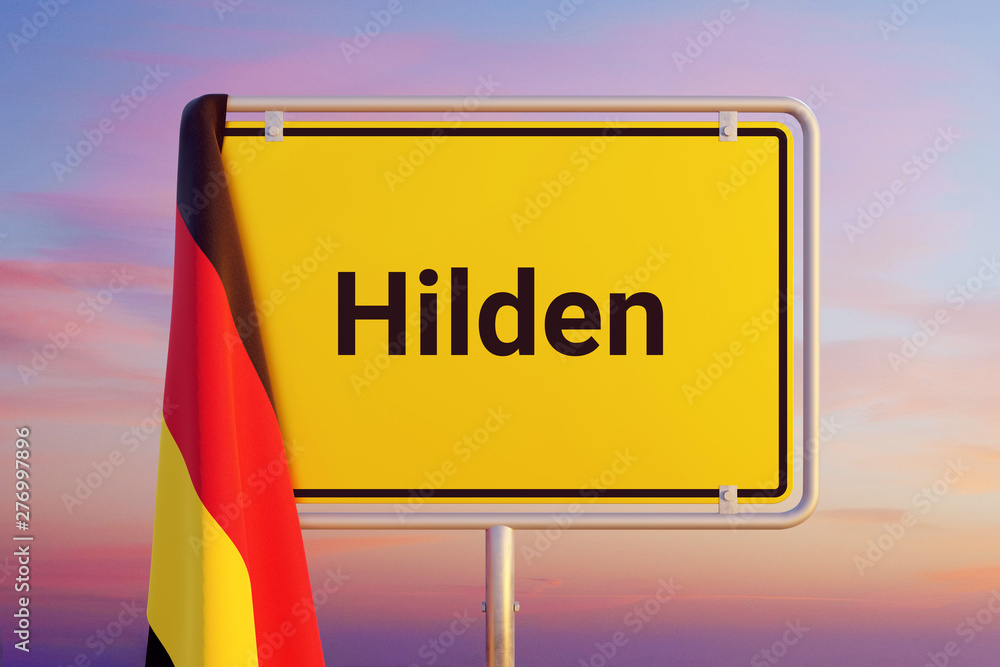 Hilden. Gelbes Schild/Ortsschild. Flagge von Deutschland hängt darüber ...