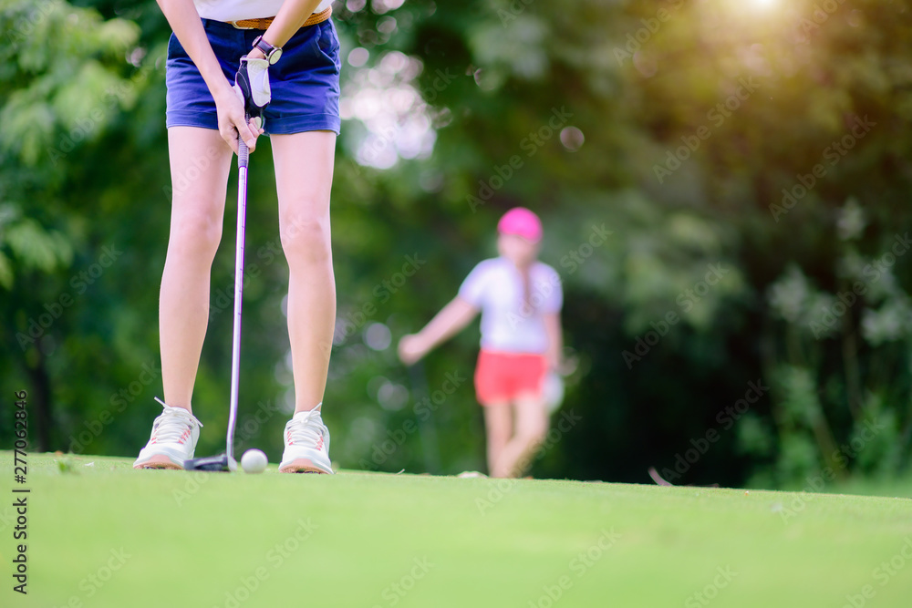 hand of young woman golf player holding putter to hit golf ball to the ...