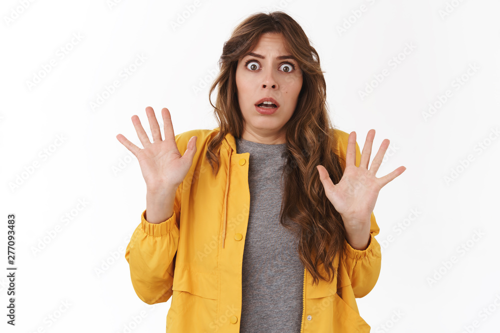 Girl saw ghost. Scared young silly timid 25s woman raising hands ...