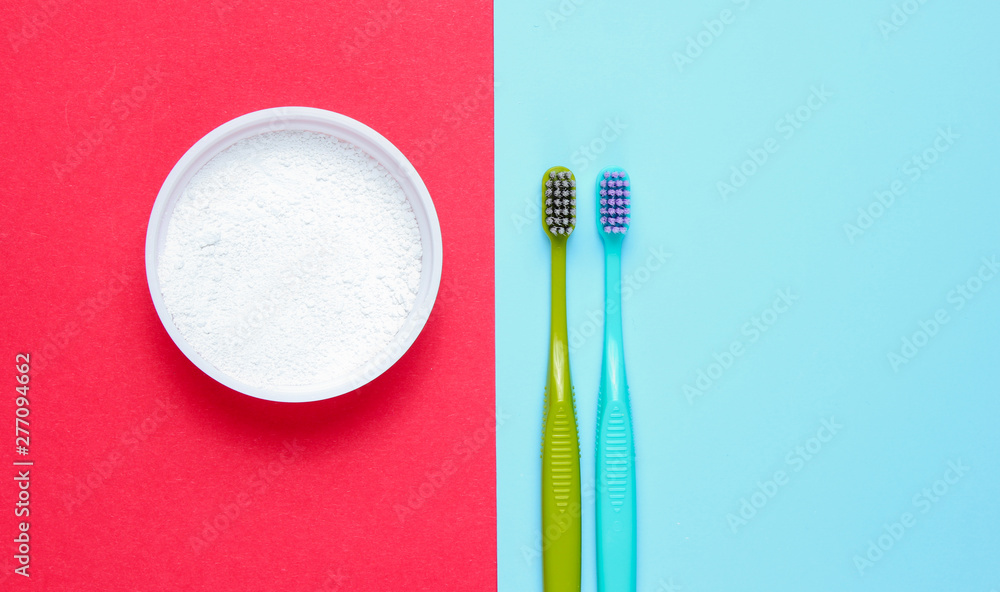Two toothbrushes, tooth powder on a colored paper background ...