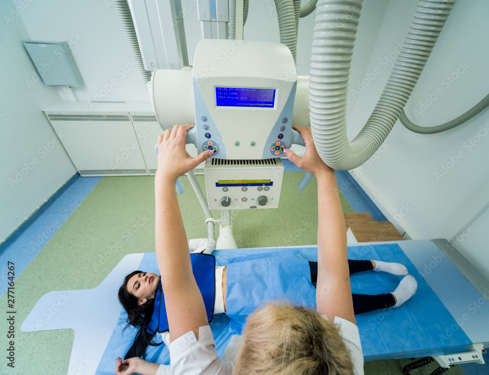 Radiologist and patient in a x-ray room. Classic ceiling-mounted x-ray ...