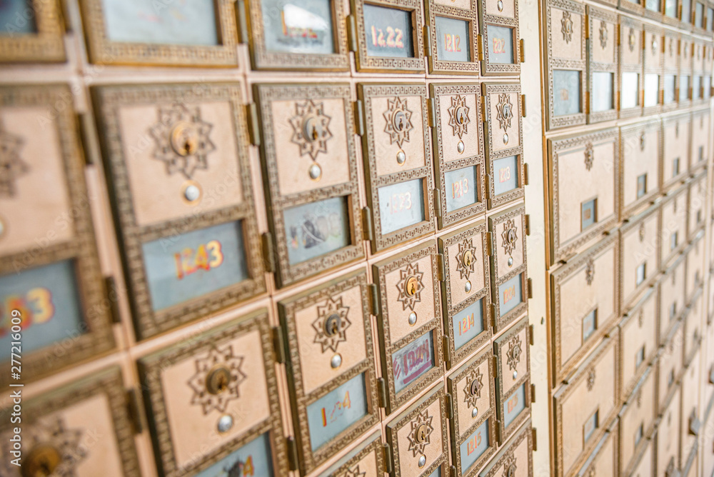 Rows of mid-century modern design post office mailboxes in brass metal ...