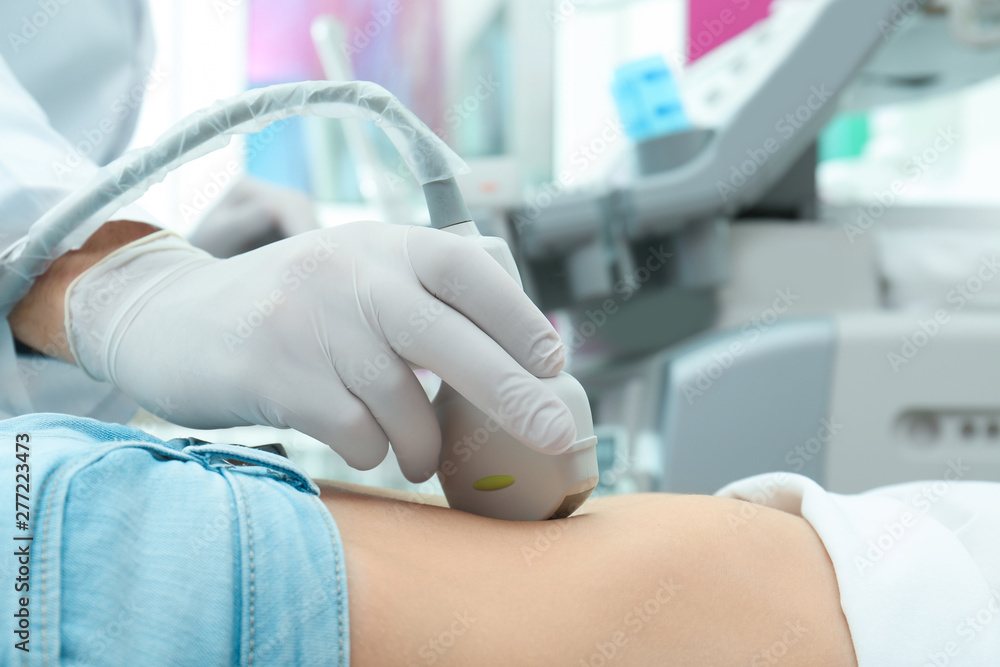 Doctor conducting ultrasound examination of internal organs in clinic ...