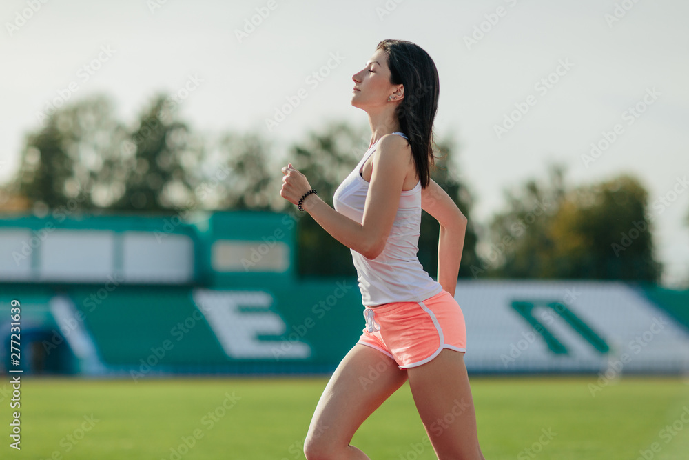 Sport. Athletic young brunette woman in pink sneakers, shorts and tops ...