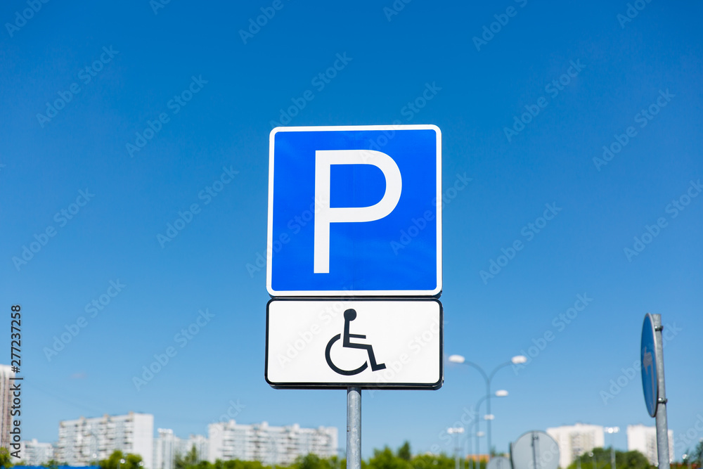 Disabled parking space and wheelchair way sign and symbols on a pole ...