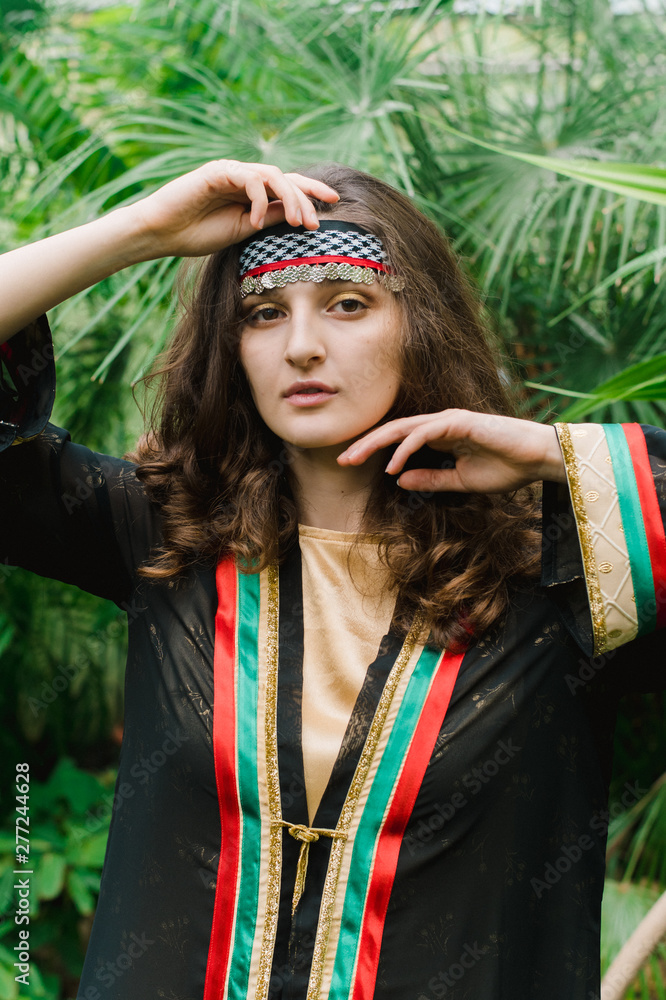 The girl from Jordan on the background of plants and palm leaves ...