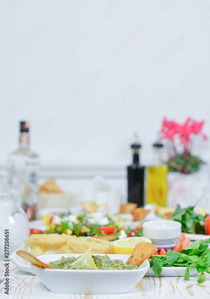 Greek food background. Meze, gyros, fried squid rings, souvlaki, uzo ...