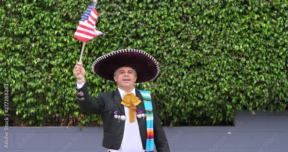 Hispanic Mexican Mariachi player musician in sombrero dances and waving ...