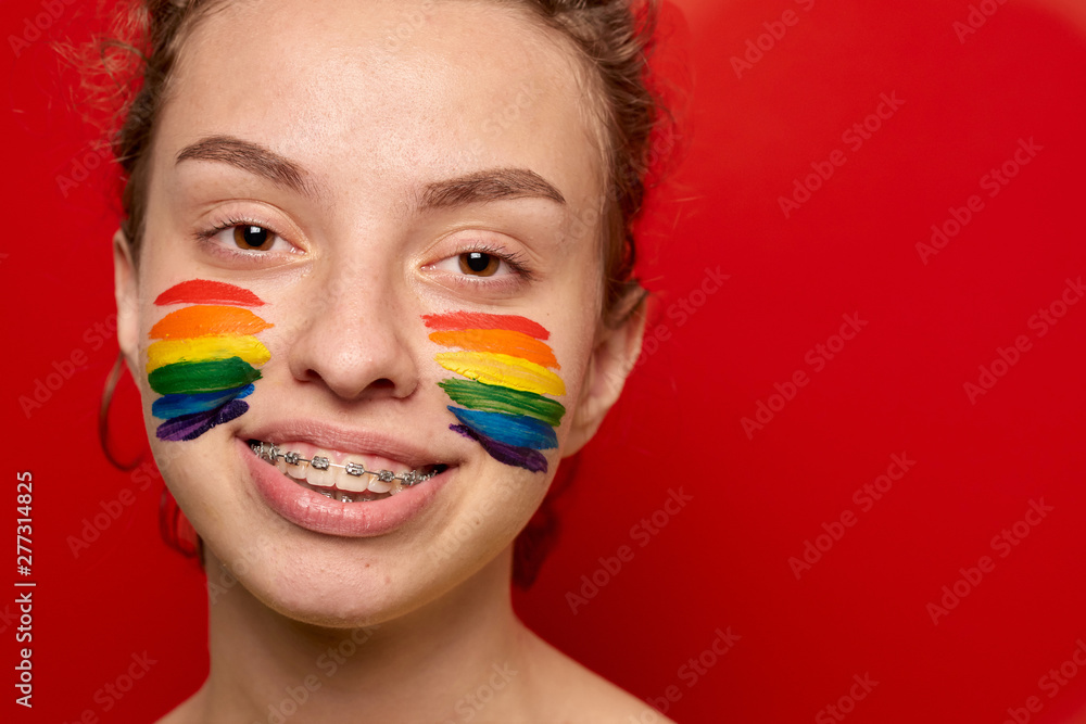 Girl with pride flag painted on her cheeks smiling Stock Photo | Adobe ...
