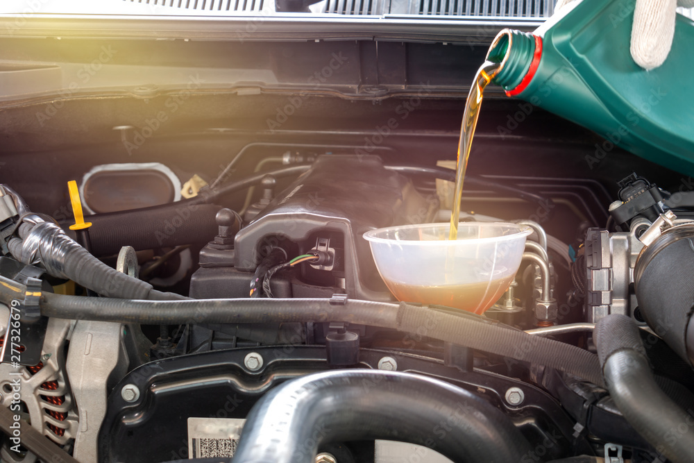 Pouring oil to car engine.Hand mechanic in repairing ,Change the Oil ...