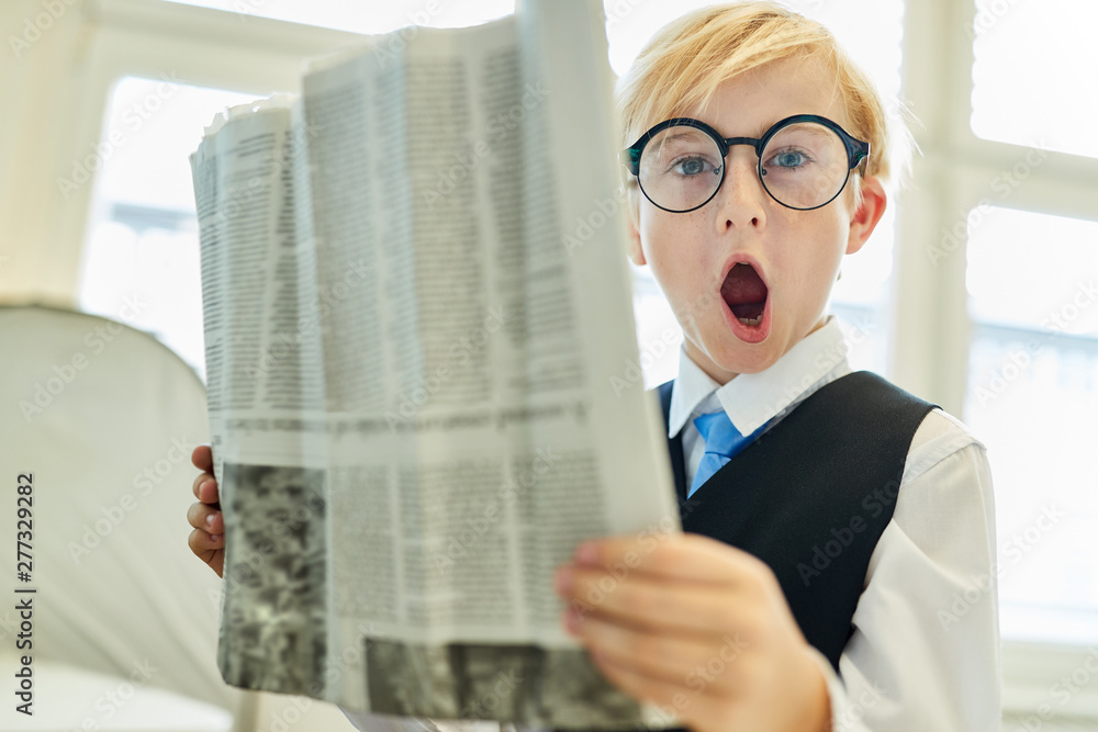 Young boy astonished while reading Stock Photo | Adobe Stock