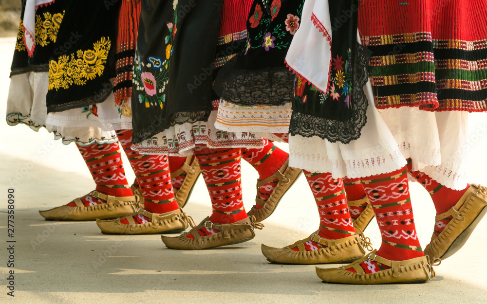 Girls dancing folk dance. People in traditional costumes dance ...