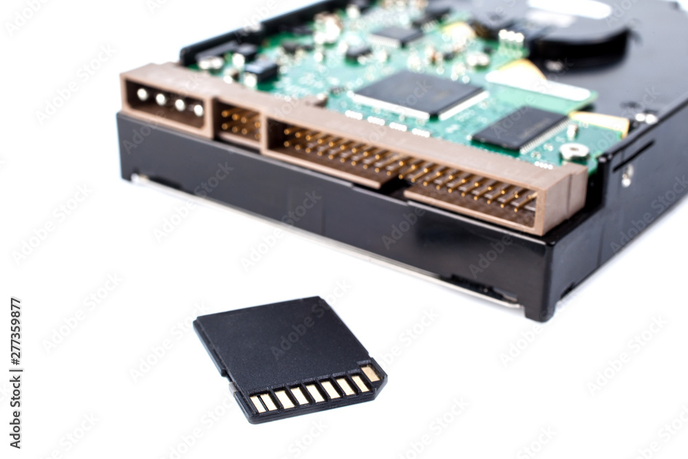 old hard drive next to modern sd memory card on white background, close ...