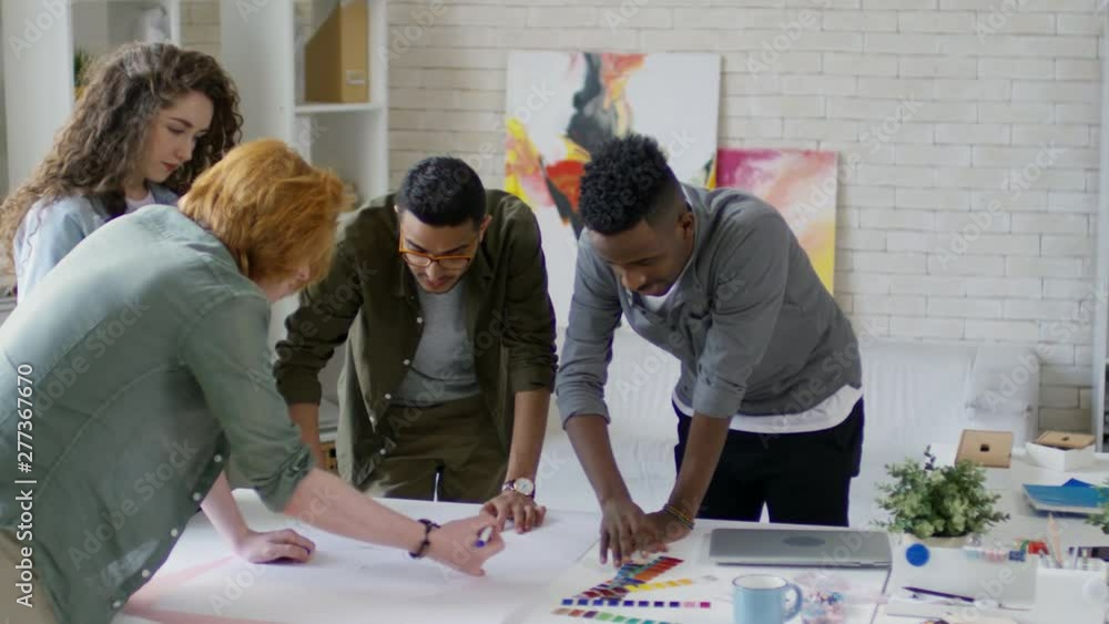 Medium shot of group of four creative casually dressed young people ...