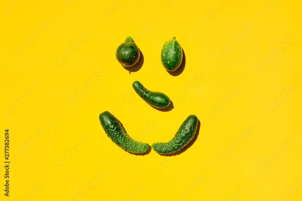 Different sizes and forms cucumbers on a yellow background forms a ...