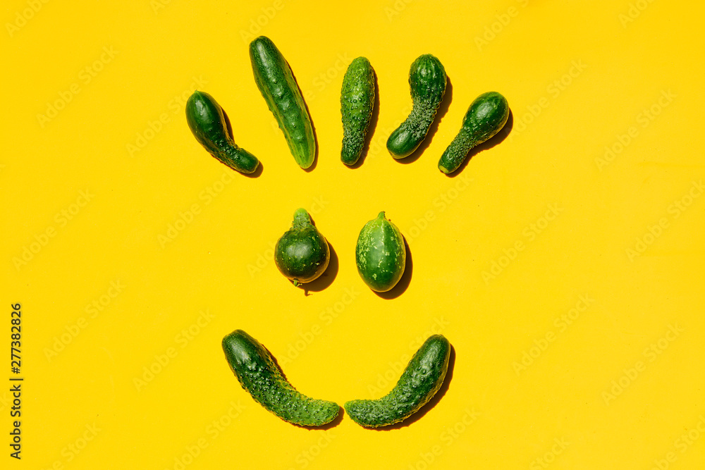 Different sizes and forms cucumbers on a yellow background forms a ...