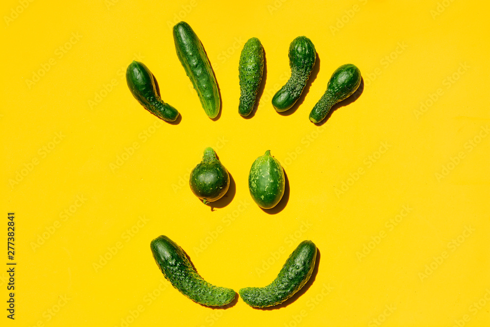 Different sizes and forms cucumbers on a yellow background forms a ...