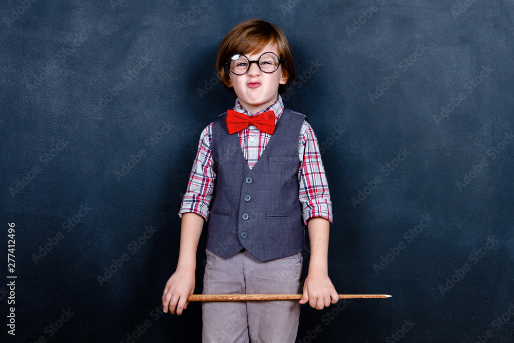 Funny intelligent smart schoolboy boy with eye glasses holding wooden ...