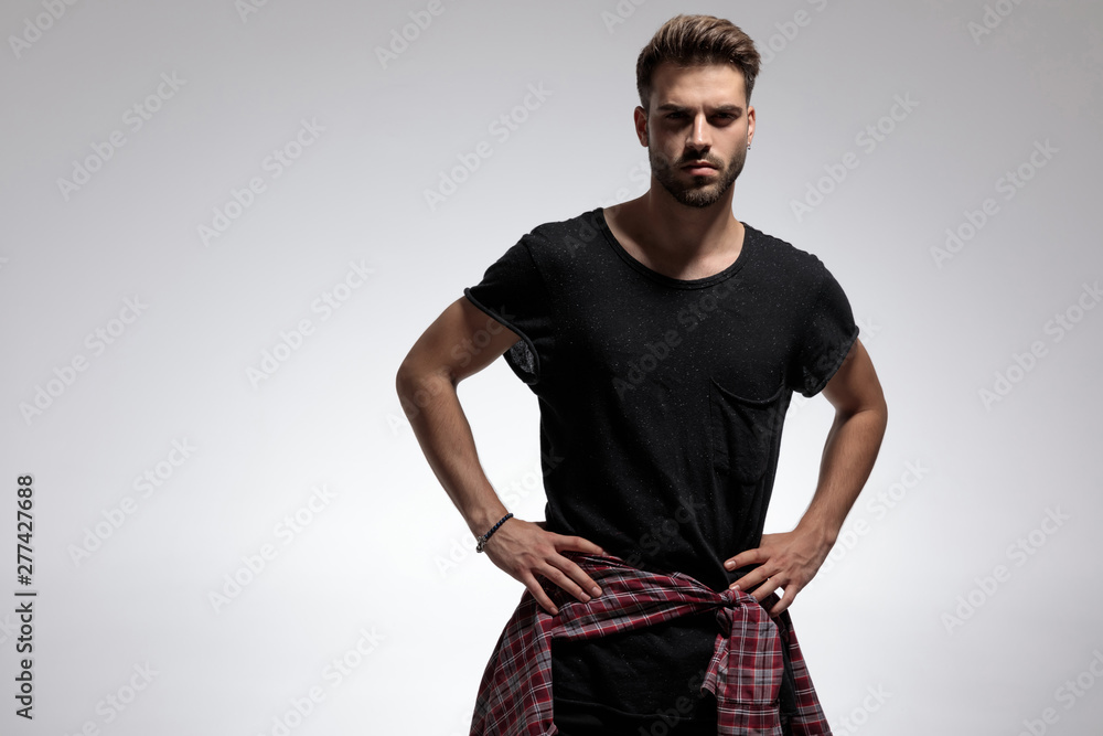 Young casual man holding his hands on his hips Stock Photo | Adobe Stock