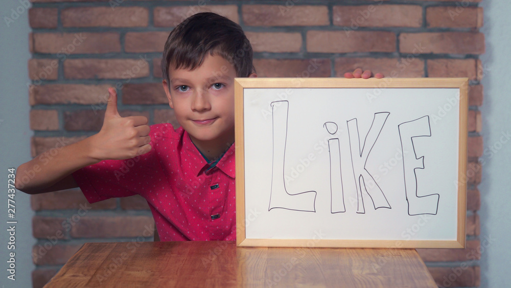 Portrait little boy showing whiteboard with handwriting word like ...