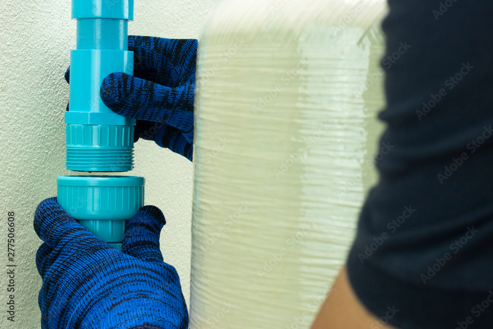 plumber conecting union pvc at storage water tank Stock Photo | Adobe Stock