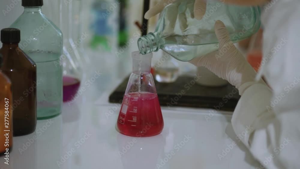 Chemistry laboratory class. Close-up of a future scientist mixing and ...