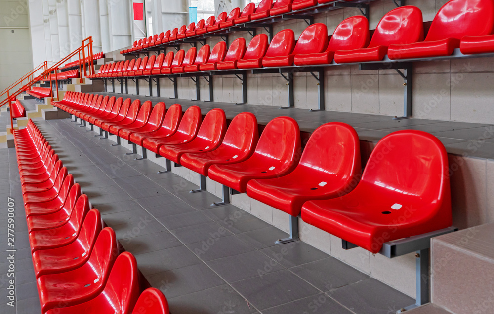Red plastic seats in the stadium. Tribune fans. Seats for spectators in ...