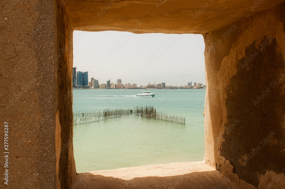 View of the sea with boat and Bahrain skyline from Bu Maher Fort in ...