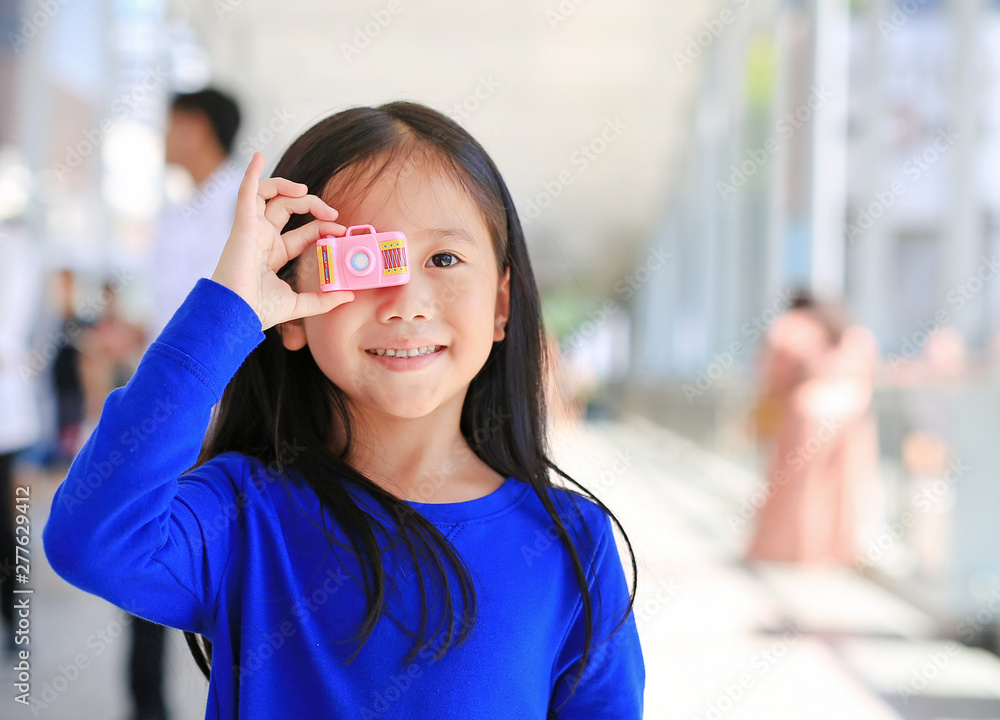 Beautiful smiling Asian little girl taking photo by toy camera to take ...