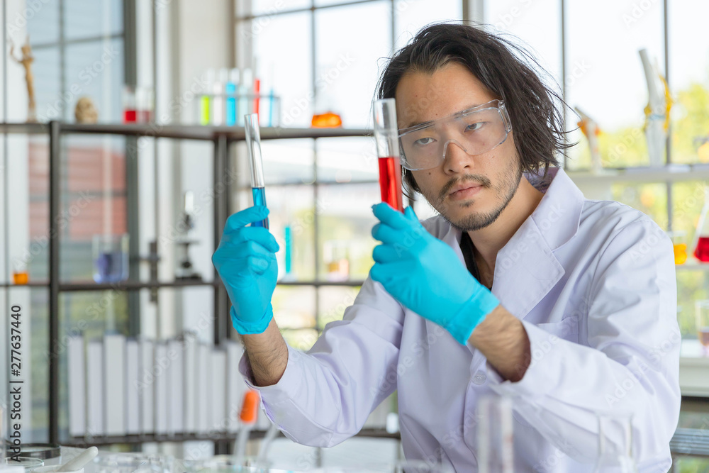 The Portrait of the Asian smart man scientist is holding two test tubes ...