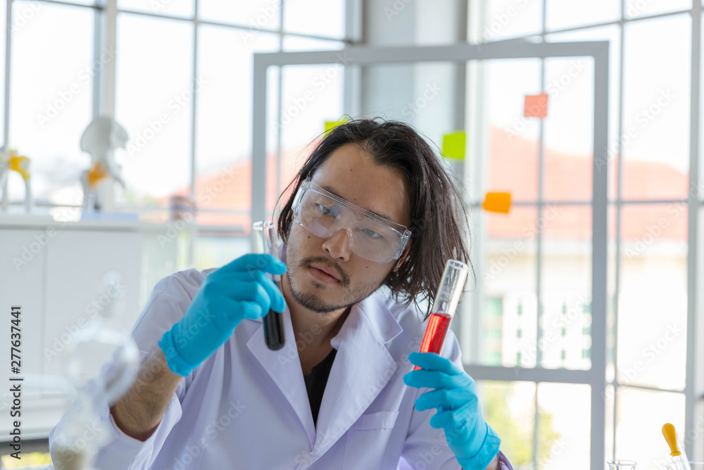 The Portrait of the Asian smart man scientist is holding two test tubes ...