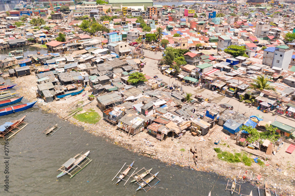 Slums in Manila, a top view. Houses of poor people and boats in poor ...