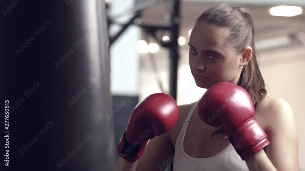 Female boxer hitting a huge punching bag at a boxing studio. Woman boxer training hard. vídeo do ...
