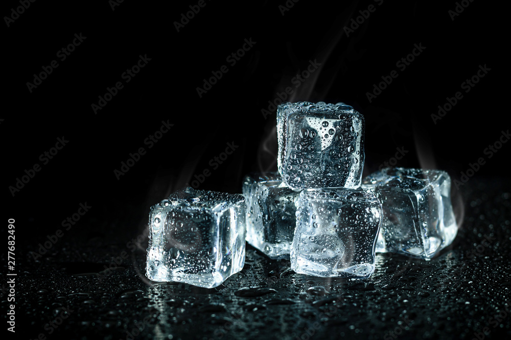 ice cubes and cooling smoke on dark table background. Ice blocks with ...