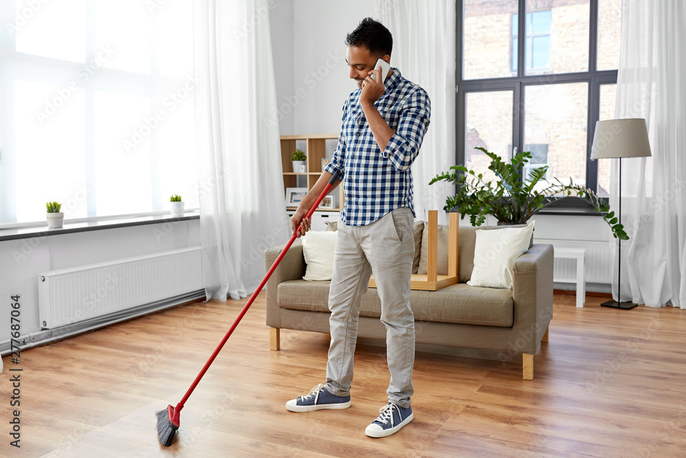 cleaning, housework and housekeeping concept - indian man with broom ...