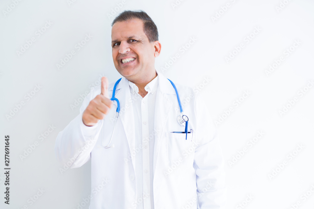 Middle age doctor man wearing stethoscope and medical coat over white ...